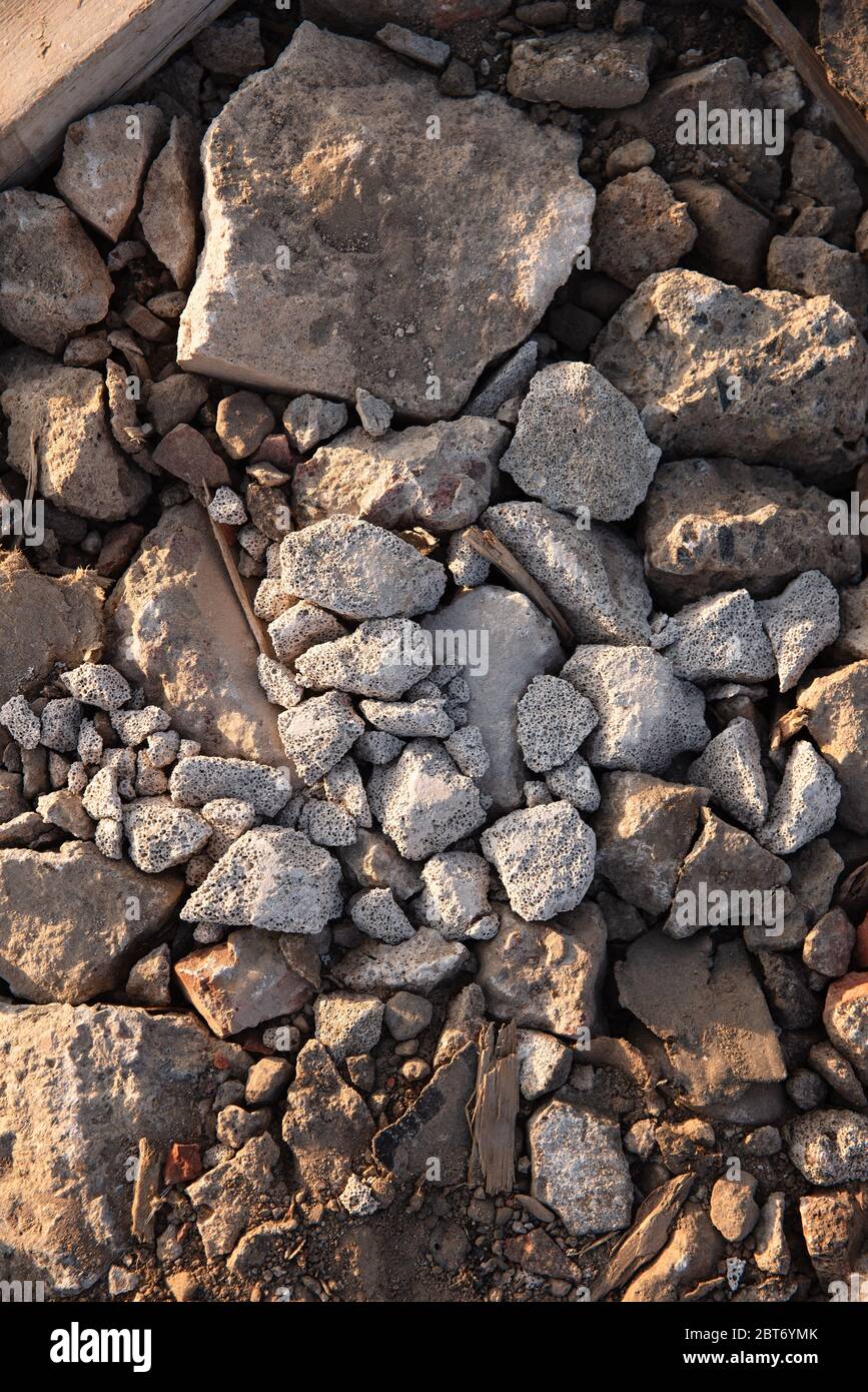 stone texture, sand and dust, yellow light, garbage at a construction ...