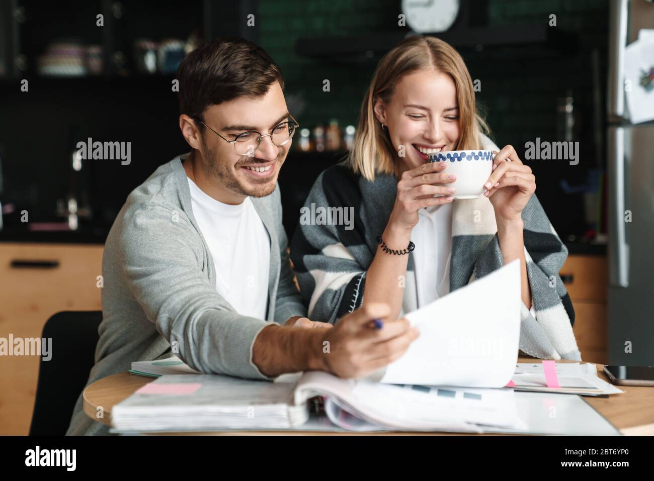 Image of happy young businesslike man and woman doing calculations and ...