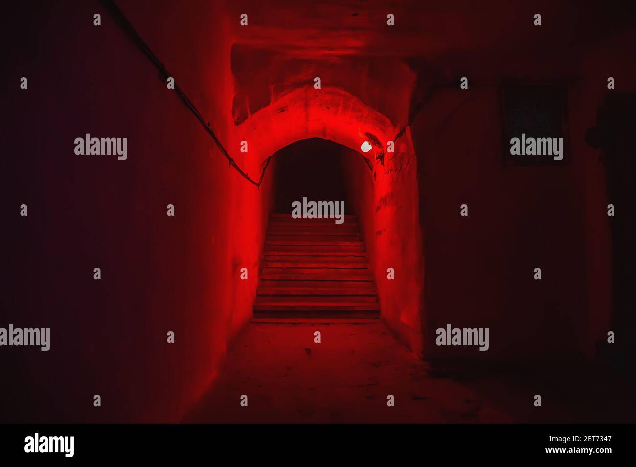 Staircase with steps in tunnel of underground military bunker with red ...