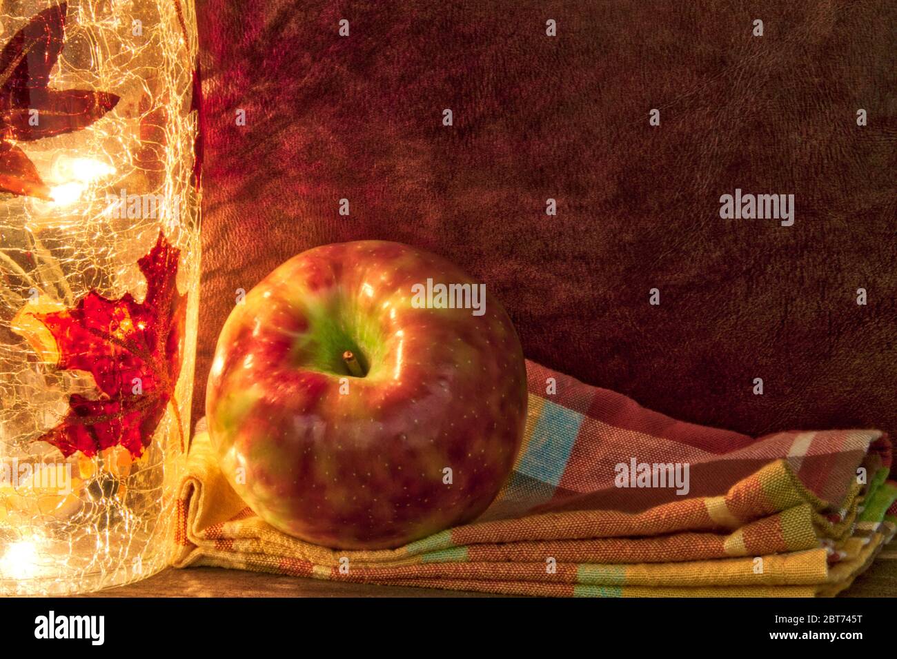 Apple in a fall theme with light and napkin and copy space Stock Photo ...