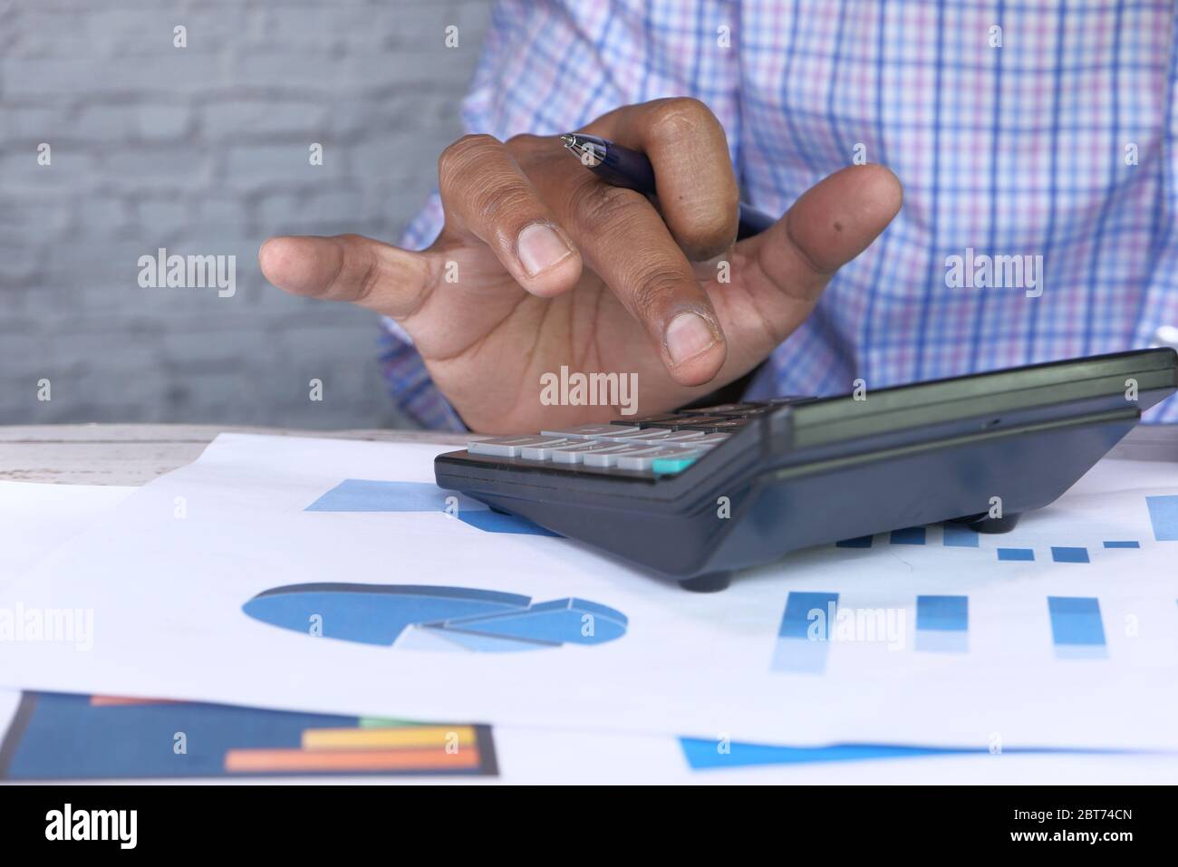person hand using calculator and analyzing charts Stock Photo - Alamy