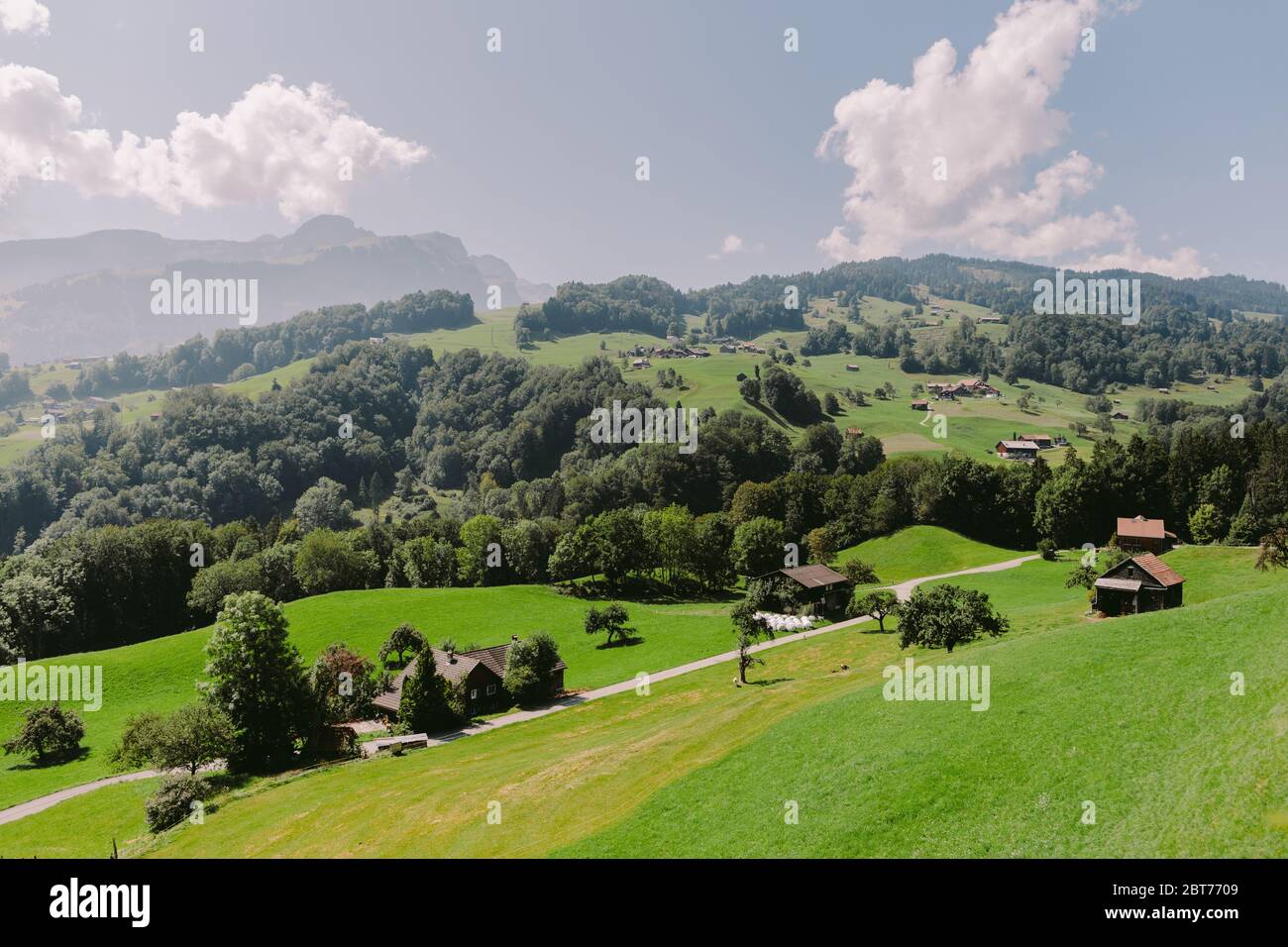 summer green countryside village scenery with hills and houses in ...
