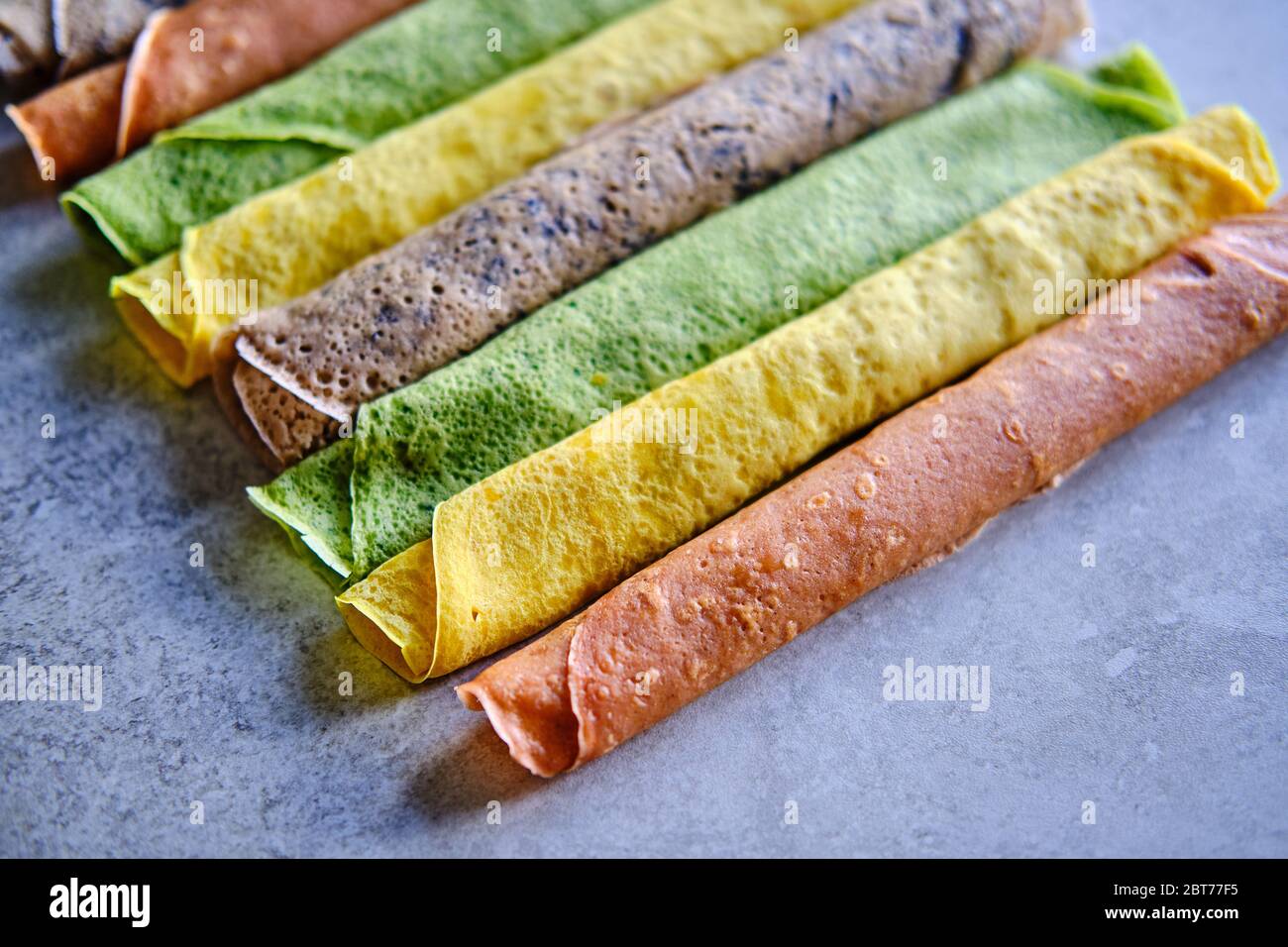 Pancakes of different color. Spinach, beetroot powder, blueberry and ...