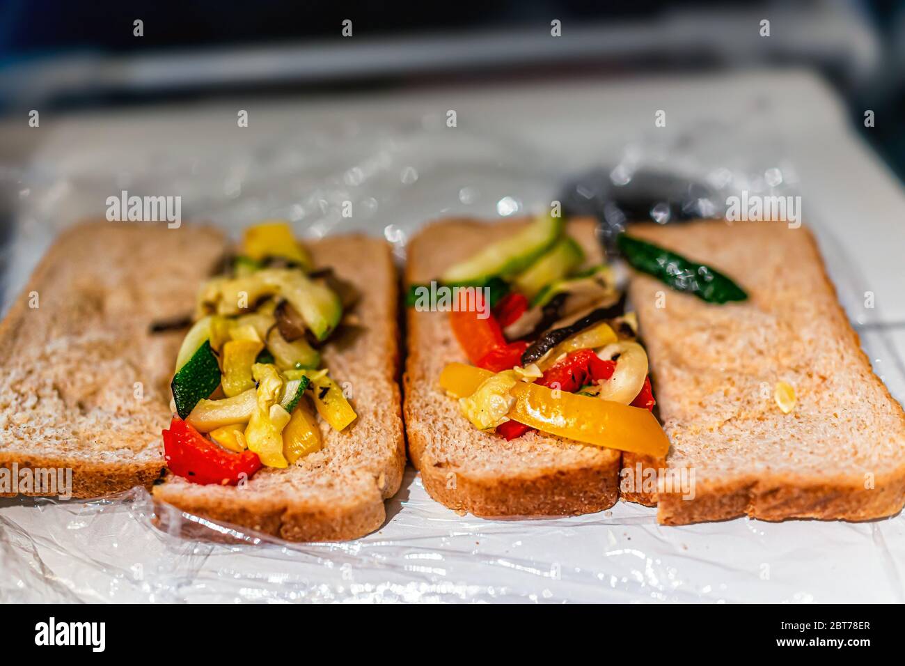 Open plastic wrapped whole wheat grain bread closeup on airplane flight ...