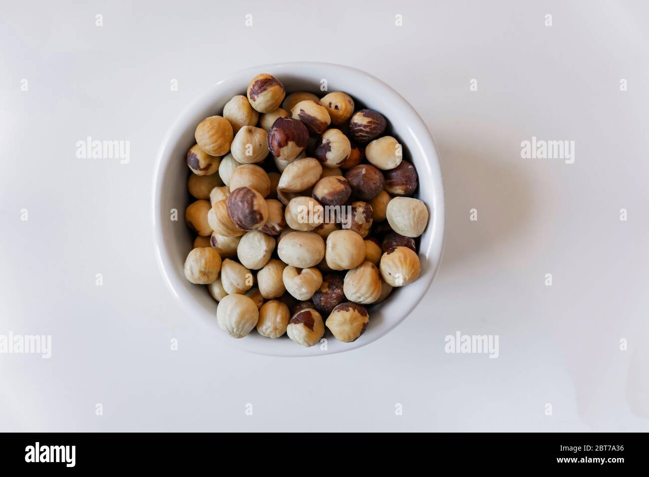 hazelnuts isolated in a white pot Stock Photo - Alamy