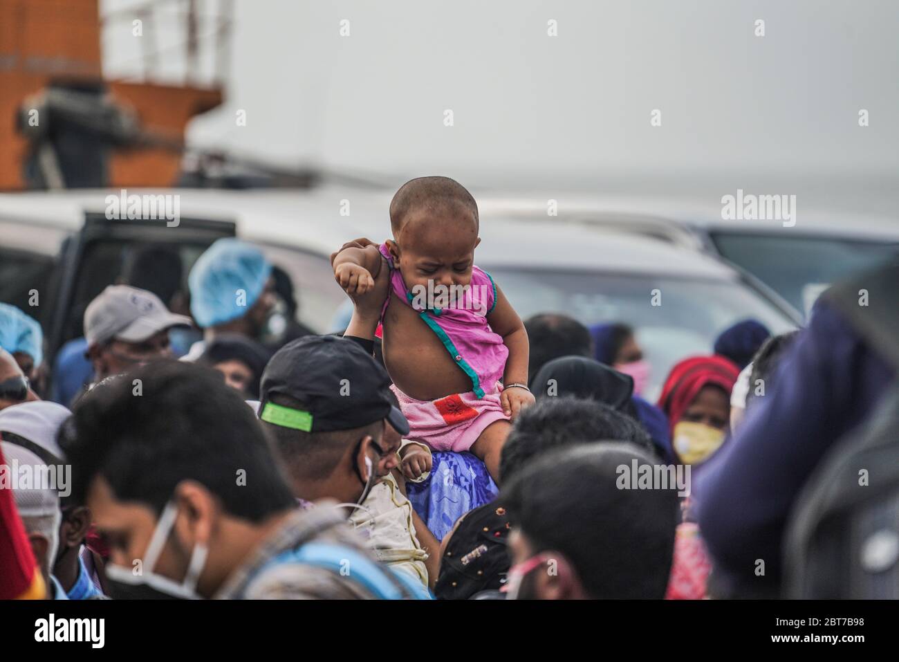 Dhaka, Bangladesh. 22nd May, 2020. A crying child is lifted high as ...