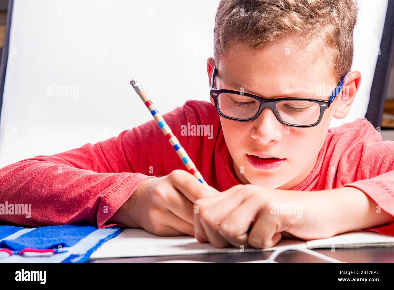 Boy at home school with pencil and math booklet while learning Stock ...