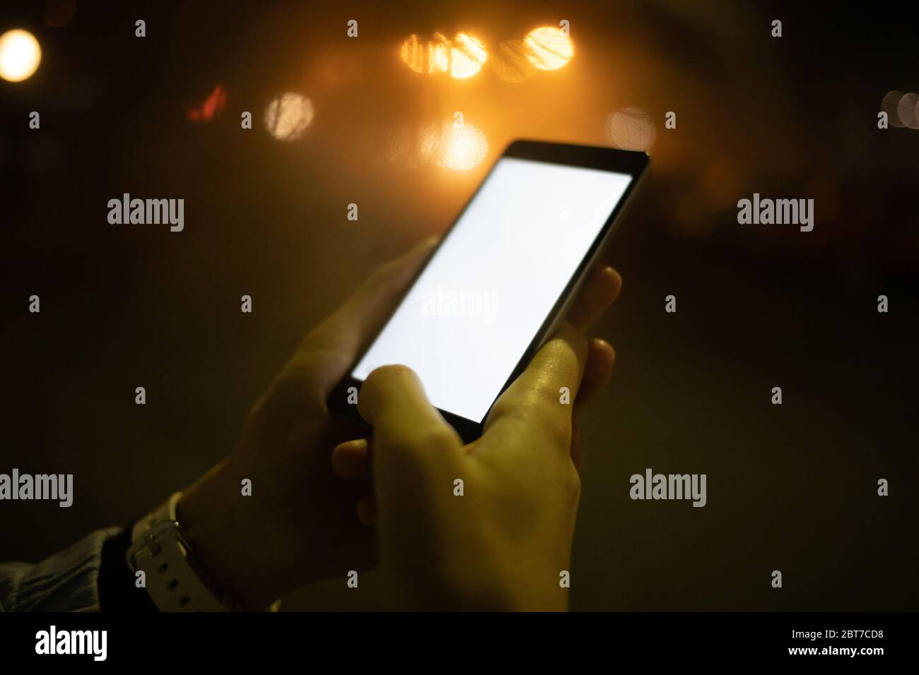 Close-up young woman hands typing in mobile phone with blank screen on ...