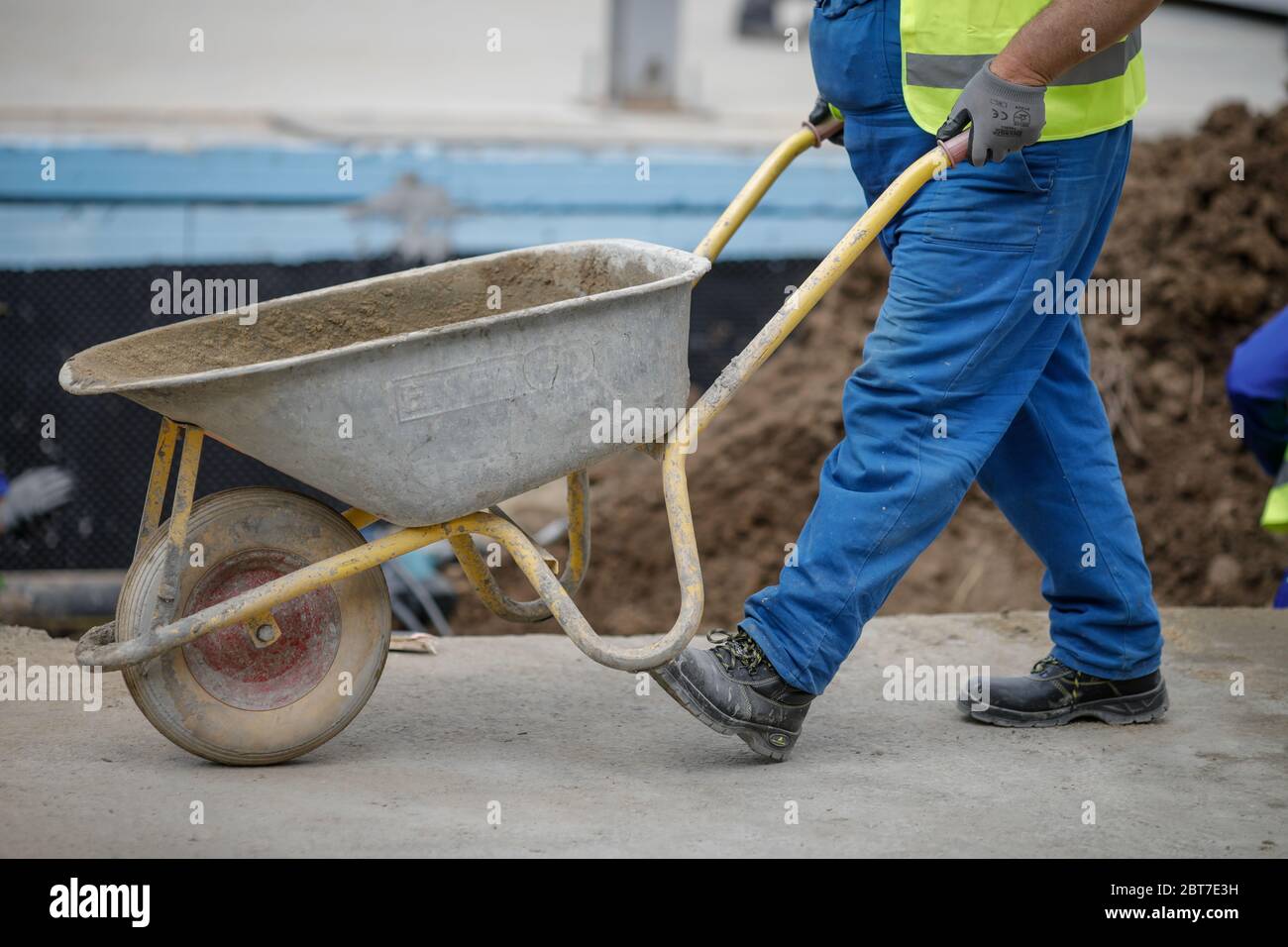Construction worker pushing a wheelbarrow hi-res stock photography and ...