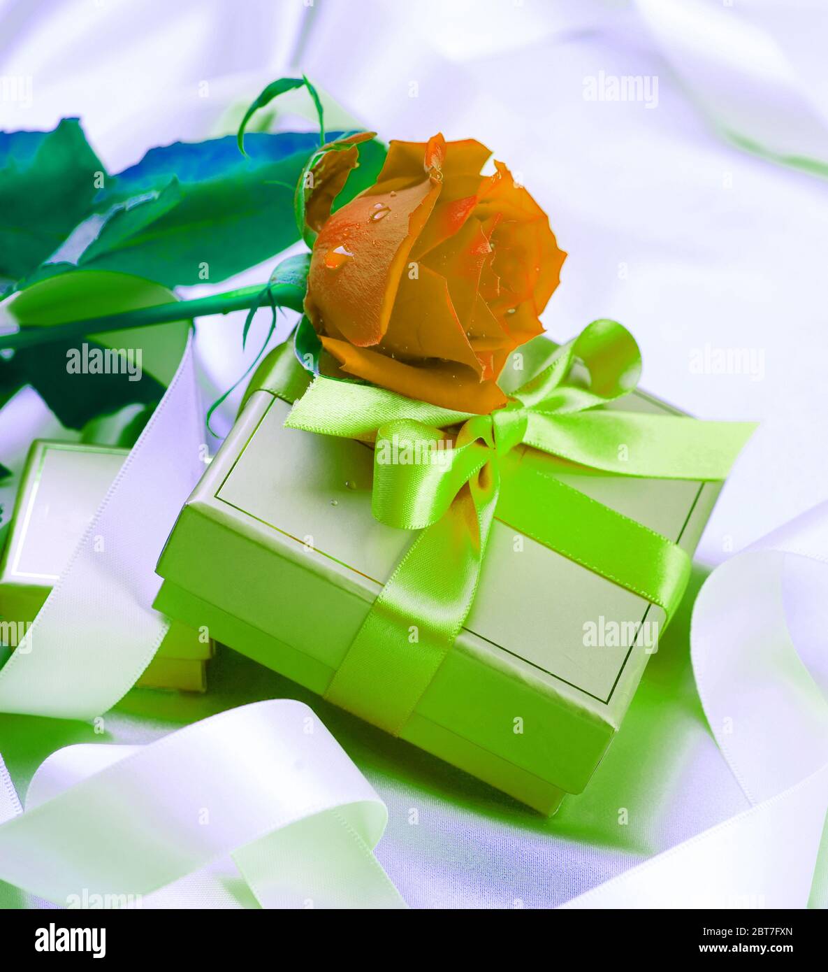 Green gift wrapped box and red rose Stock Photo - Alamy