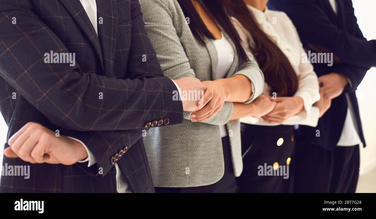 Creative faceless business people team holding hands while standing ...