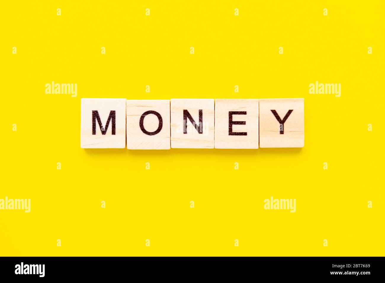 Wooden blocks with the lettering word Money on top of yellow background ...