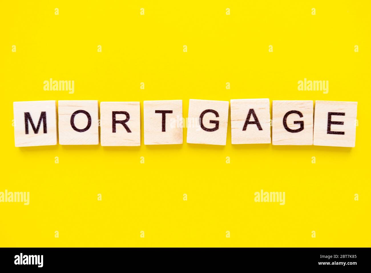 Wooden blocks with the lettering word mortgage on top of yellow ...