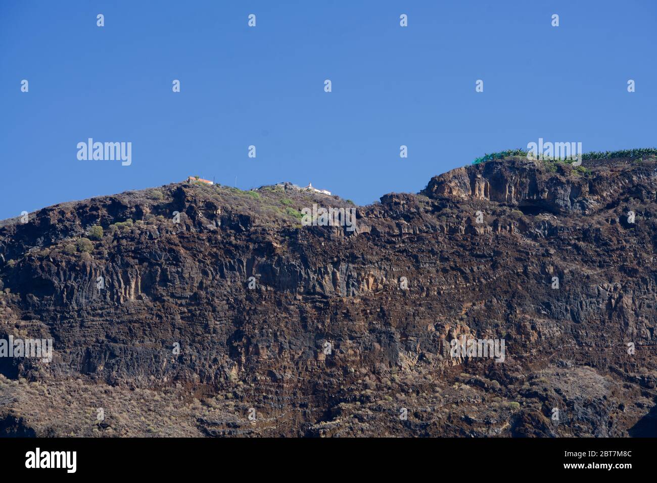 little houses on a big cliff under a perfect blue sky Stock Photo - Alamy