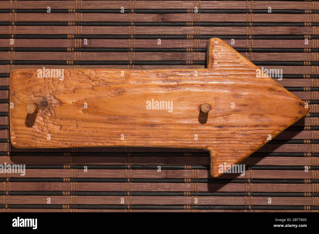 Wooden pointer made of wood with a wooden gag lie on a bamboo mat. Top ...