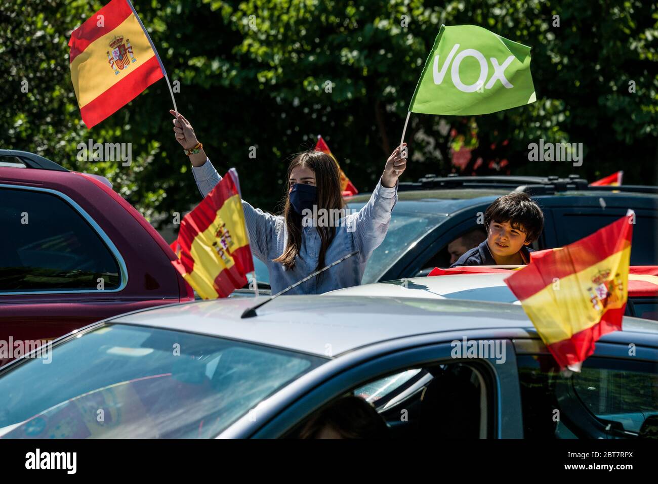 A young girl wearing a face mask waves a Spanish and far-right party ...