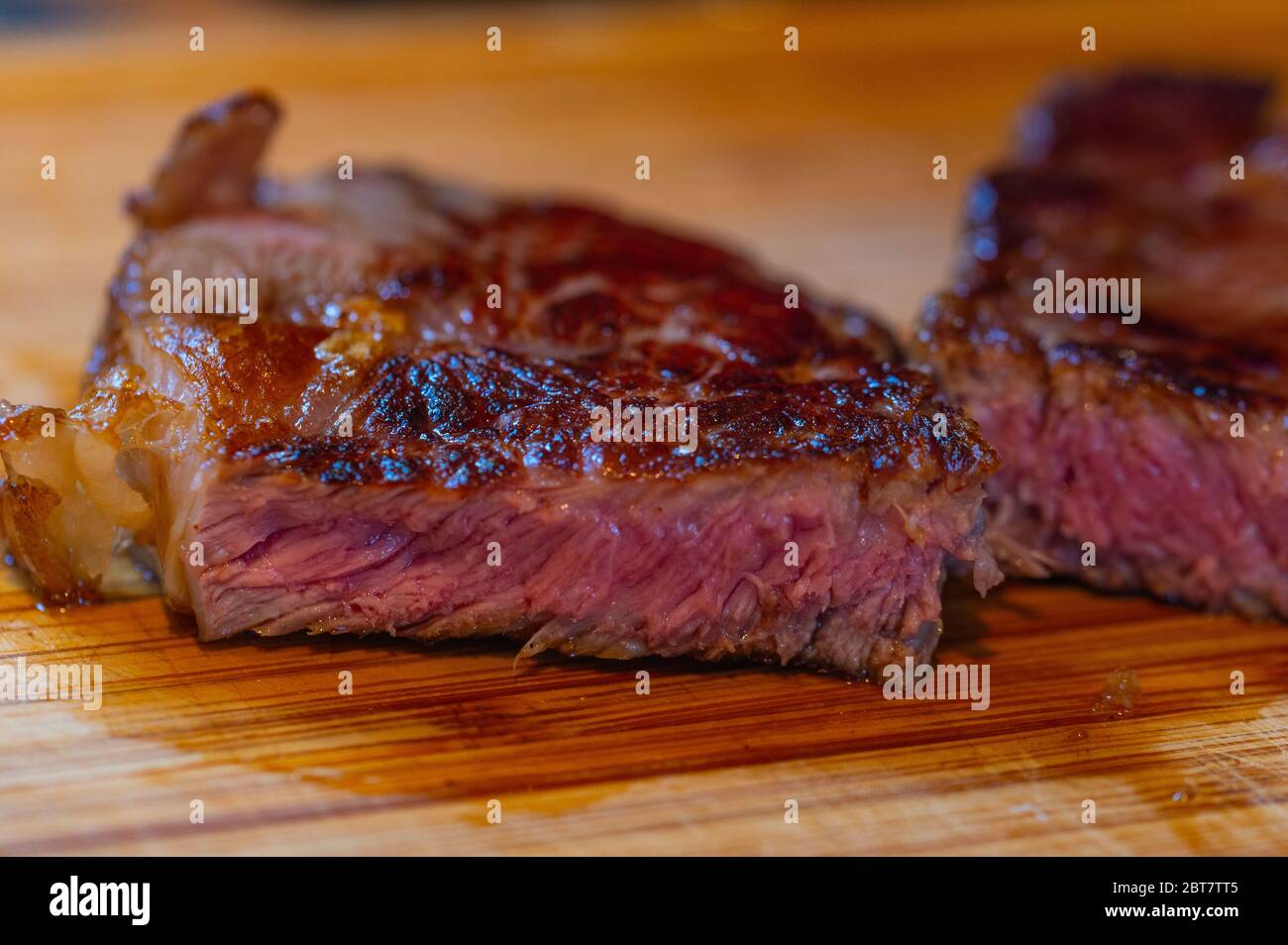 Shots of a sliced fresh rump steak with fat on the steak on a wooden ...