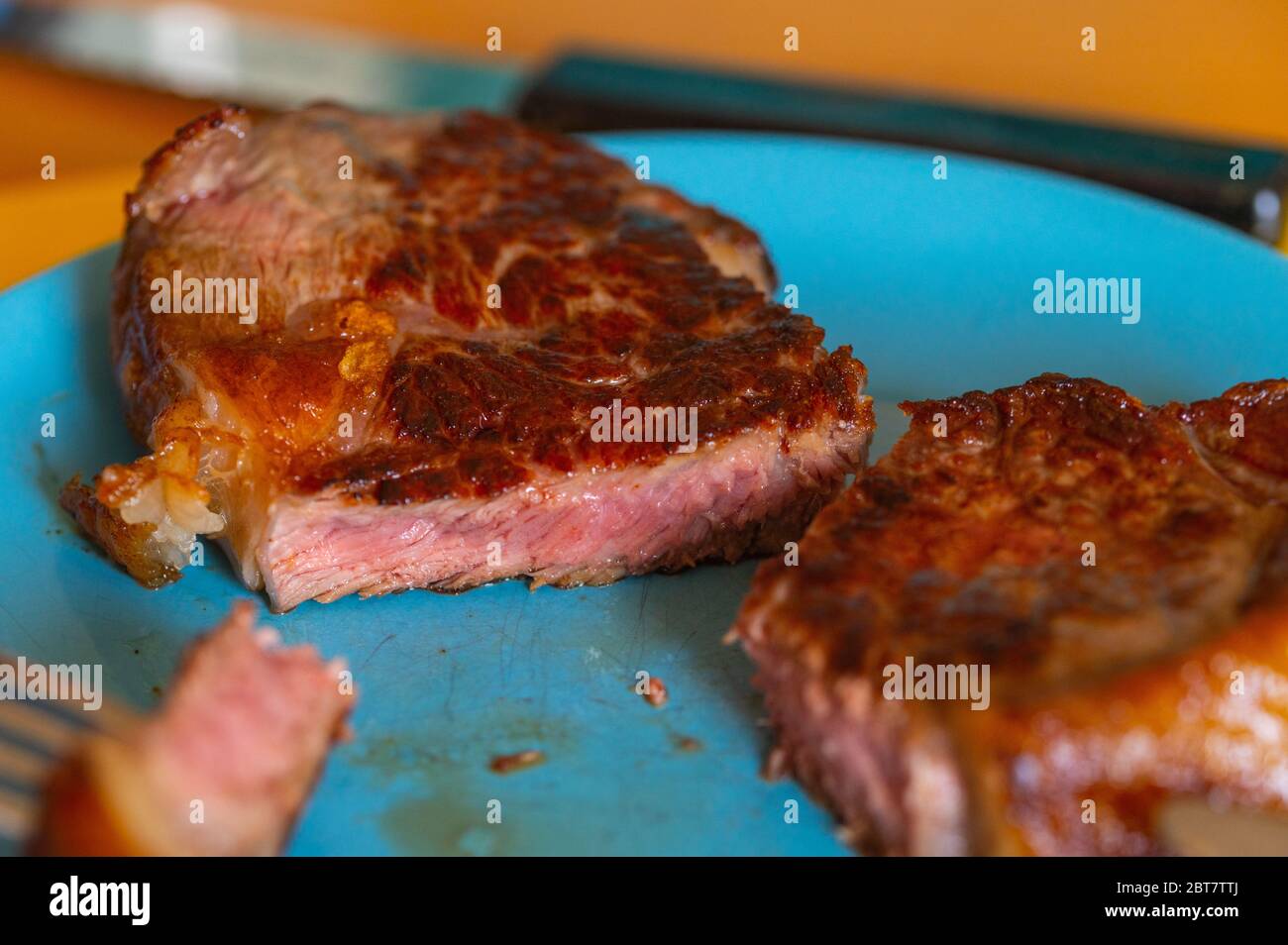 Pictures of a sliced fresh rump steak with fat on the steak on a plate ...