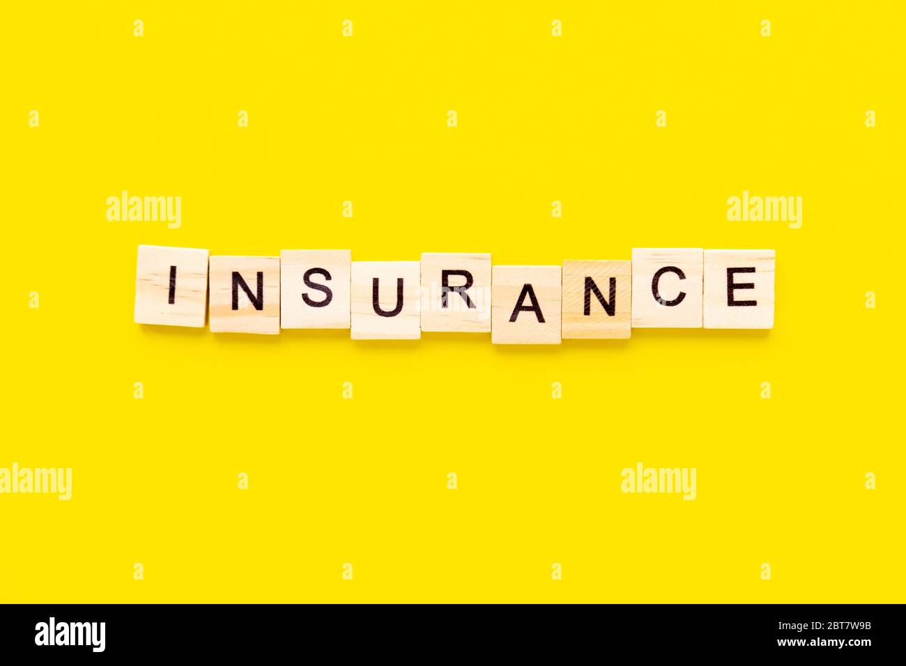 word insurance. Wooden blocks with lettering on top of yellow ...