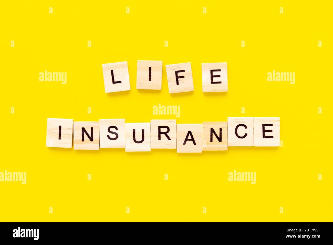 words life insurance. Wooden blocks with lettering on top of yellow ...