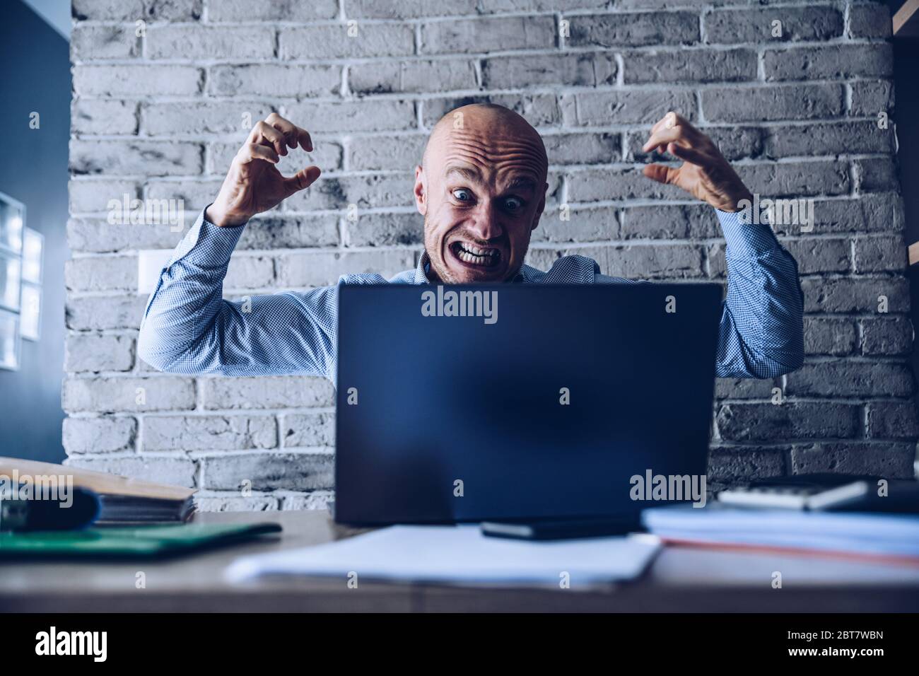 Angry and furious man working on laptop computer Stock Photo - Alamy
