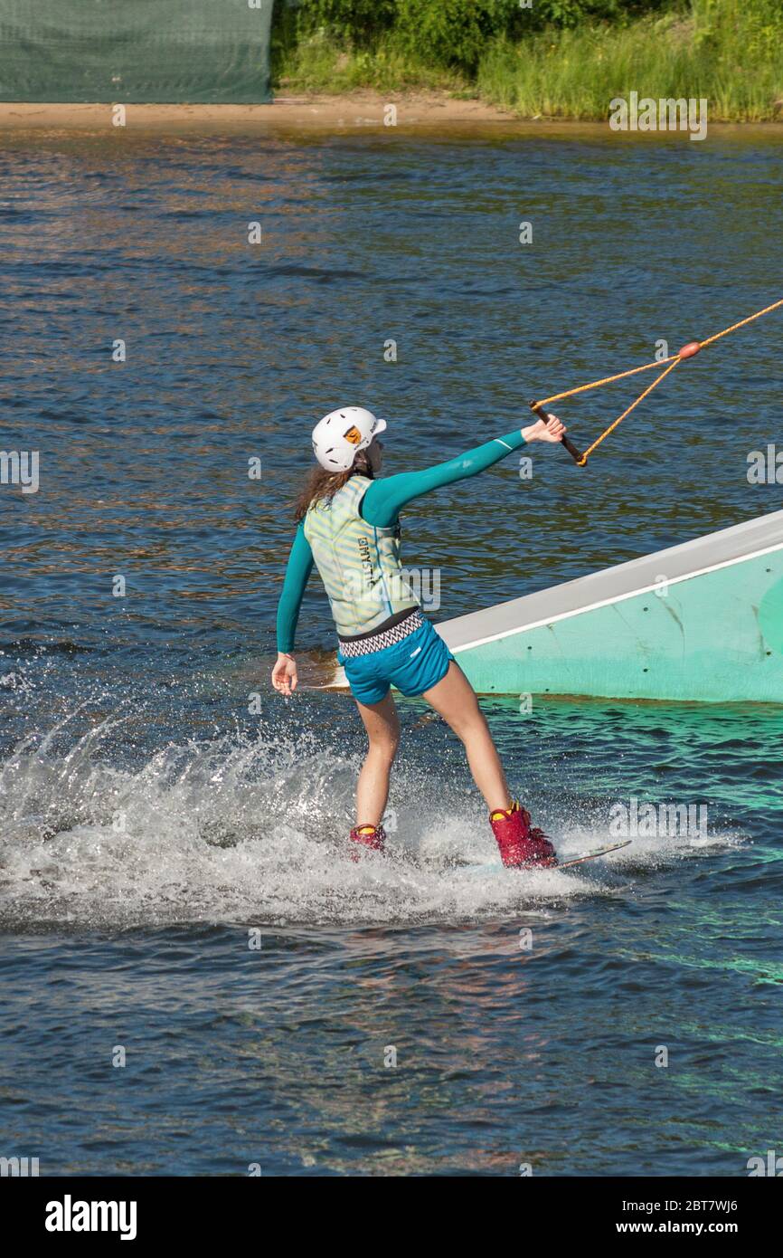 KYIV, UKRAINE - JUNE 05, 2015: Young woman wakesurfing at cables wake ...