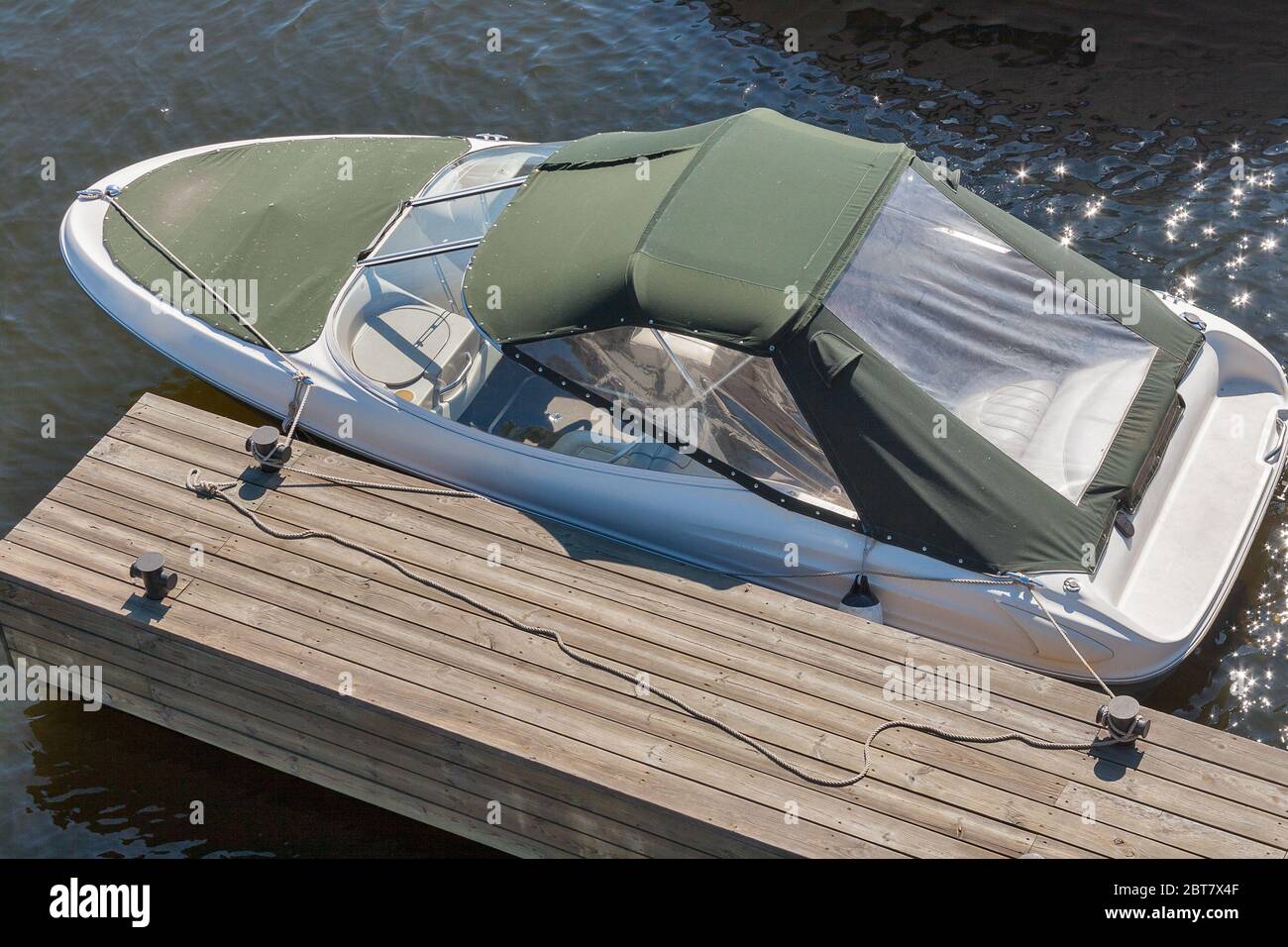 Luxury boat moored on a sunny day, view from above. Wooden pier at ...
