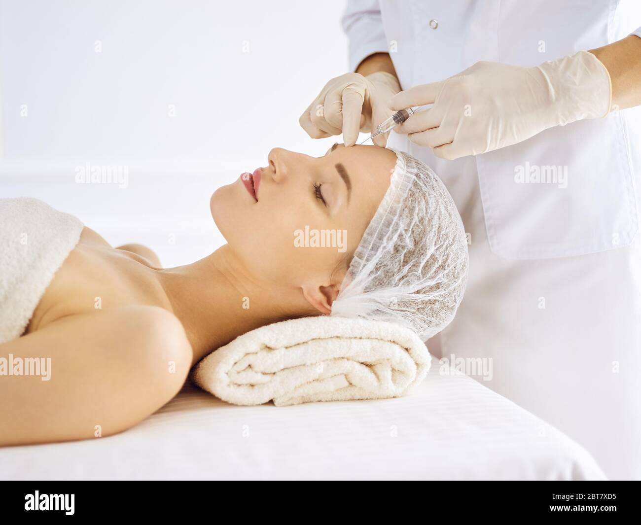 Beautiful woman receiving beauty injections with closed eyes ...