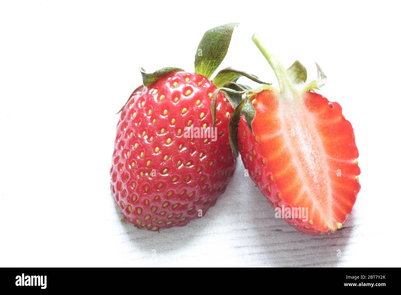 Fresh red strawberry cut in half on a white background. Healthy food ...