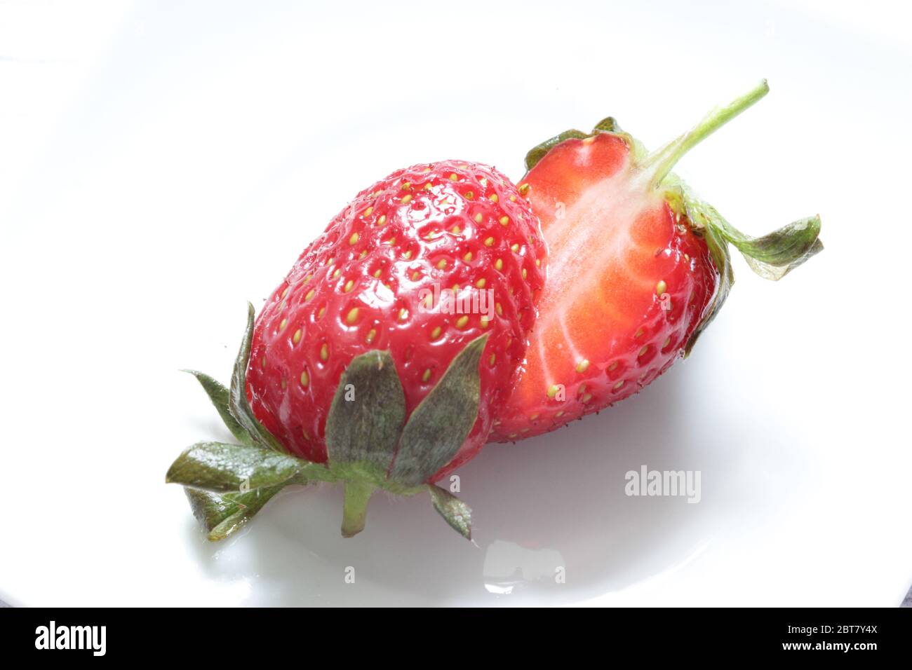 Fresh red strawberry cut in half on a white background. Healthy food ...