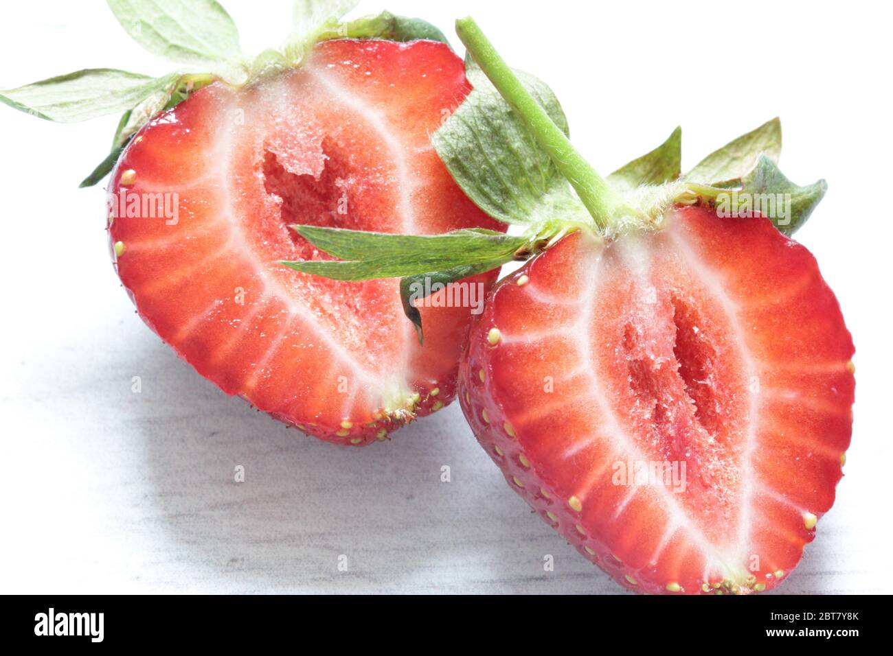 Fresh red strawberry cut in half on a white background. Healthy food ...