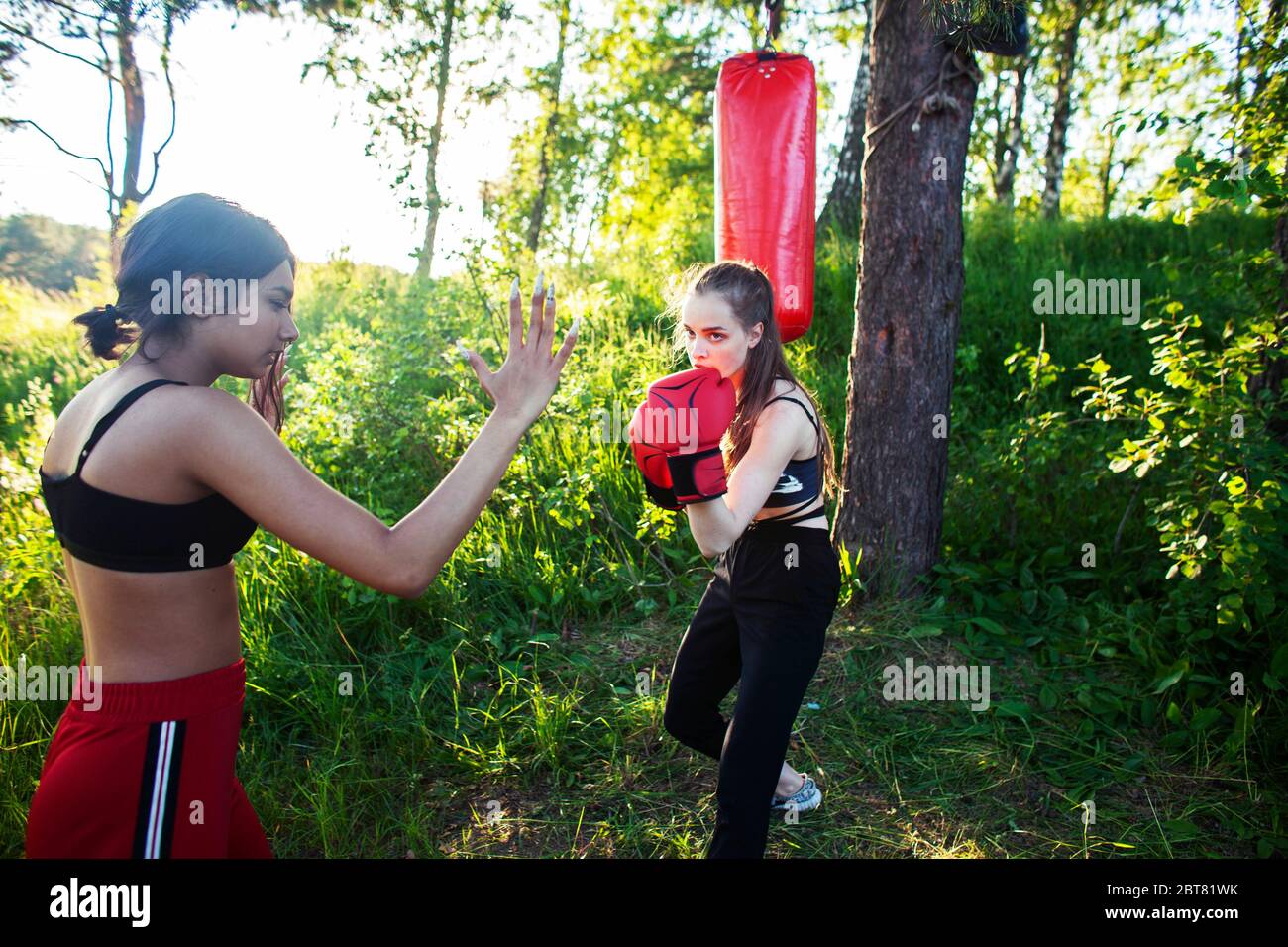 two diverse nations girls fighting boxing outside in green park, sport ...