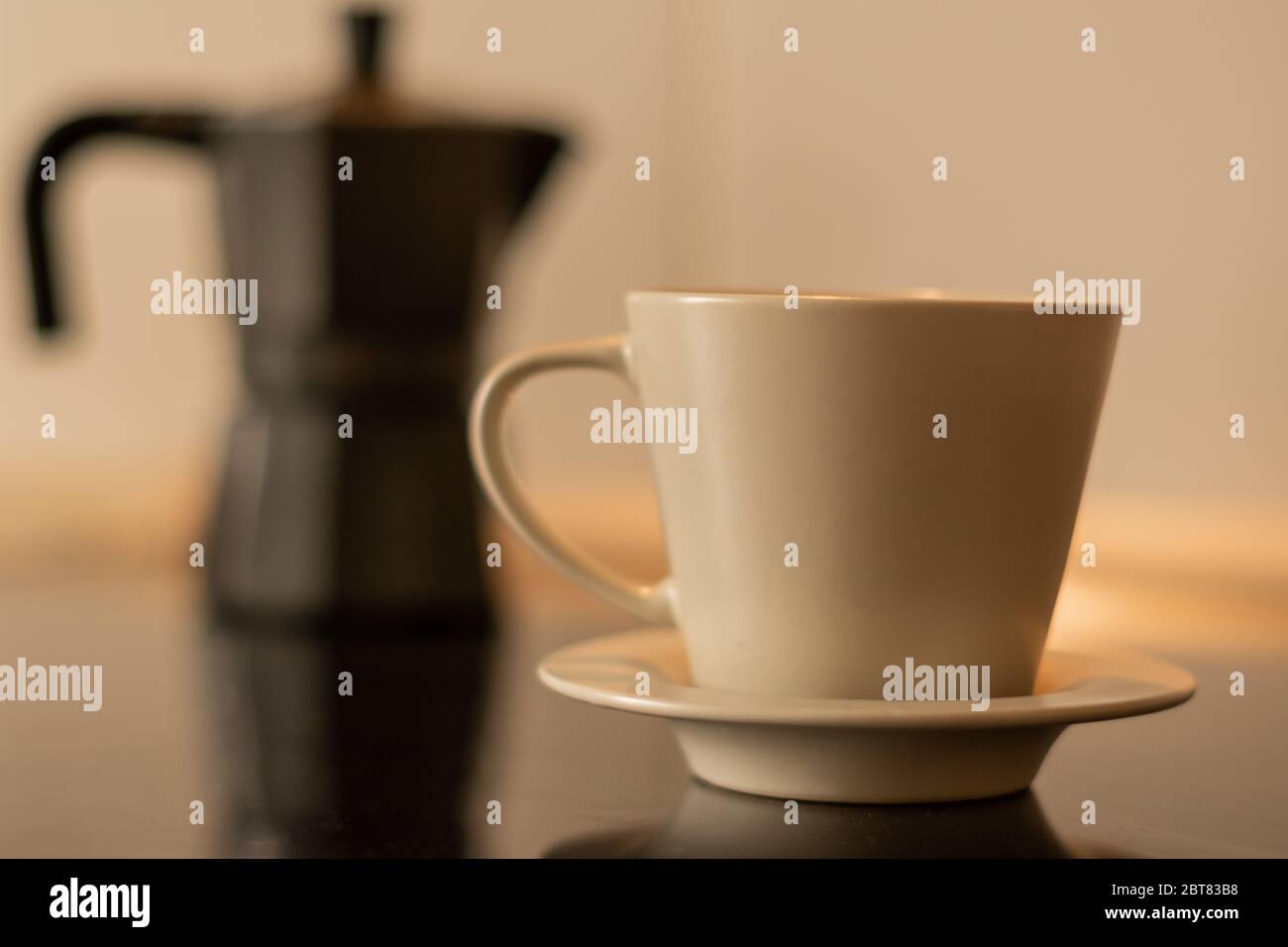 Coffee cup with a coffee maker in the background and out of focus Stock ...
