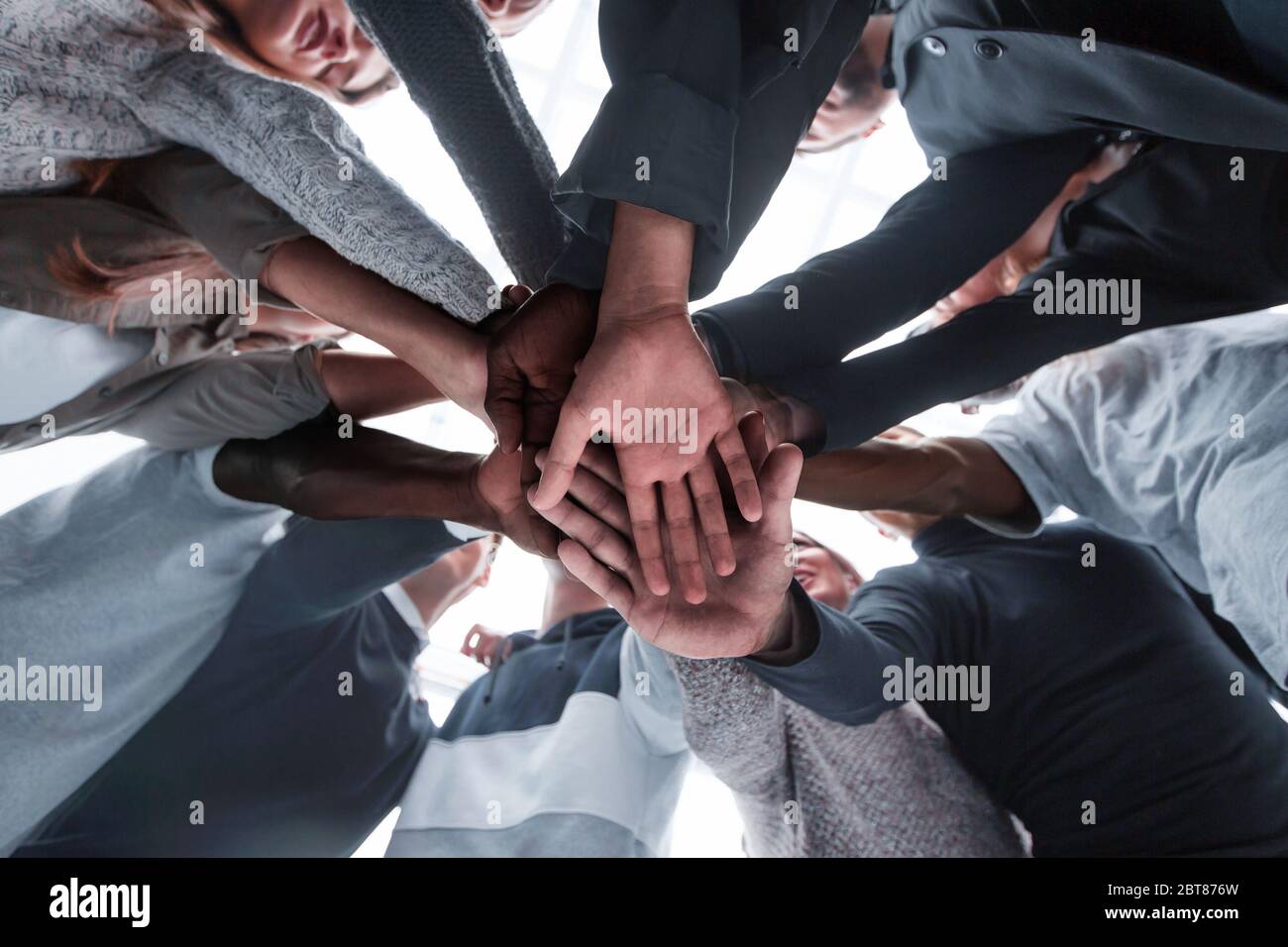 bottom view. group of happy young people making a tower out of their ...