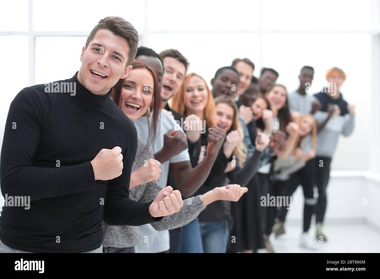 young man standing in front of a group of young people Stock Photo - Alamy