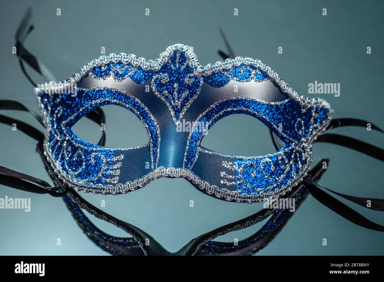 The Colombina, blue carnival or masquerade mask on black mirror ...