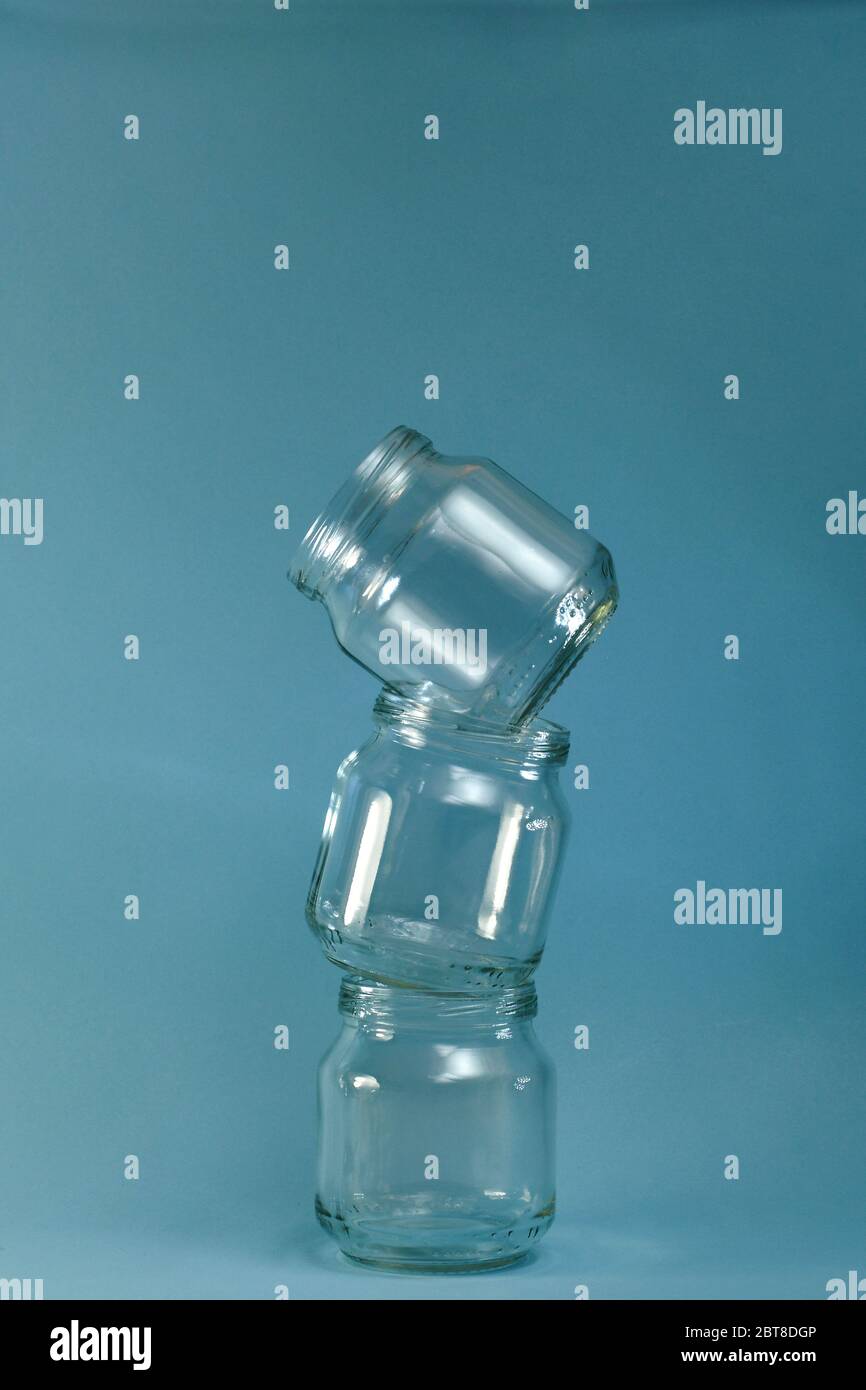 Vertical row of glass curved pyramid built jars on a vertical blue ...