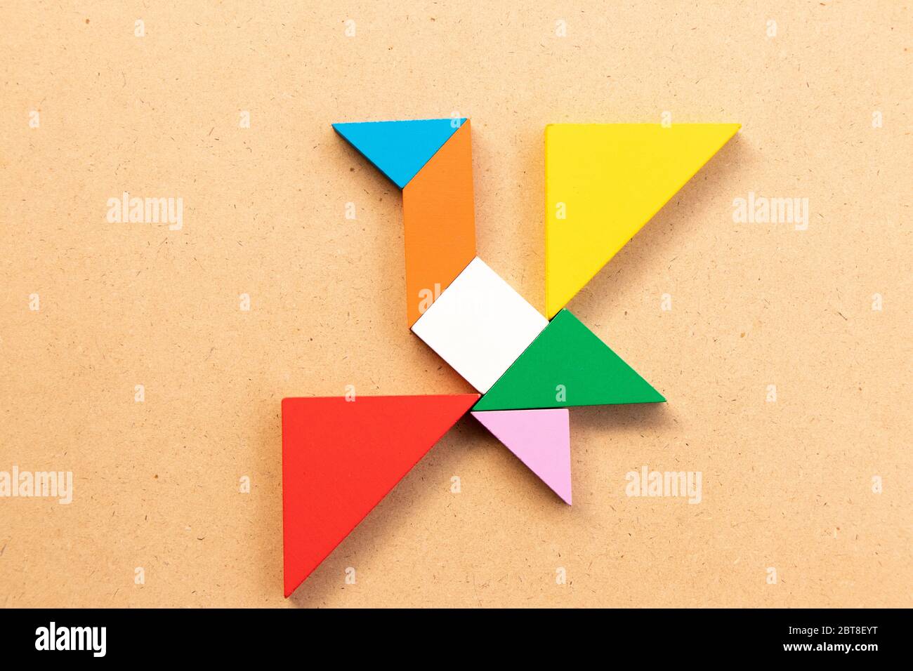 Color tangram puzzle in flying bird shape on wood bacground Stock Photo ...