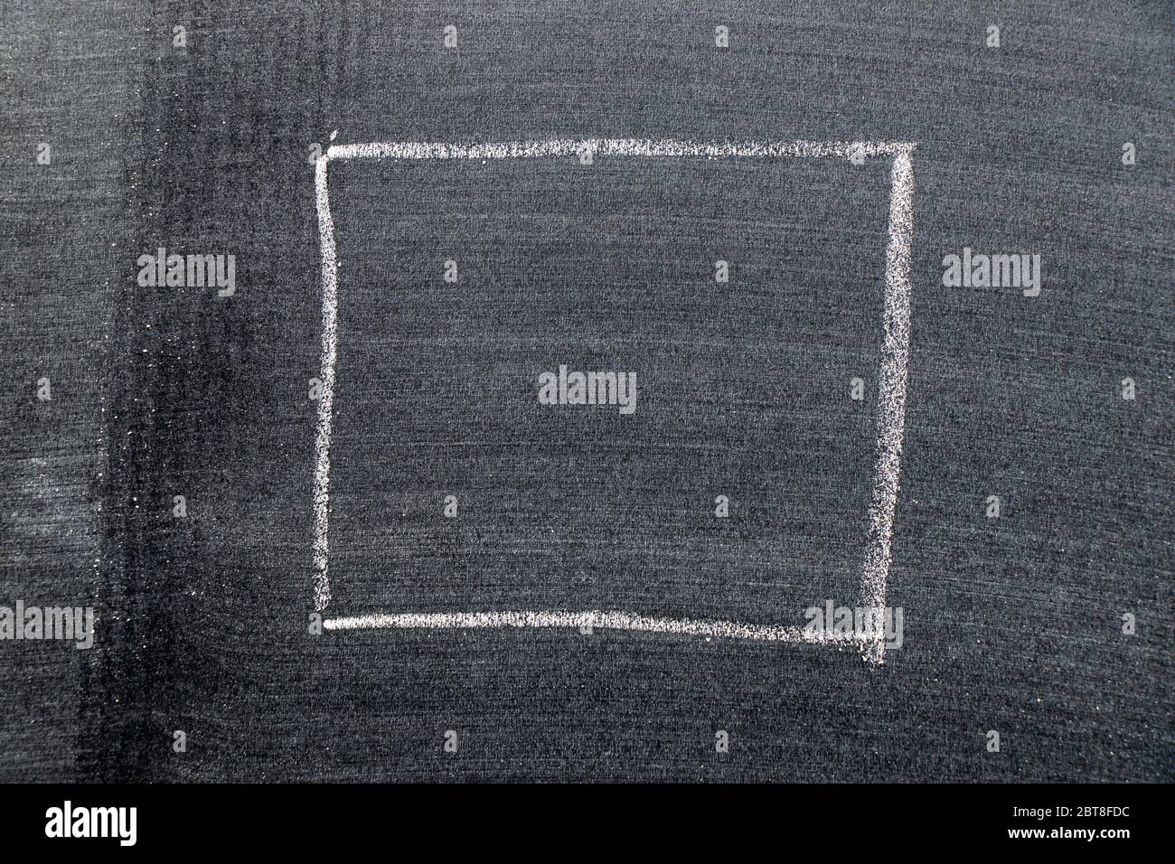 White color chalk hand drawing in square shape on black board ...