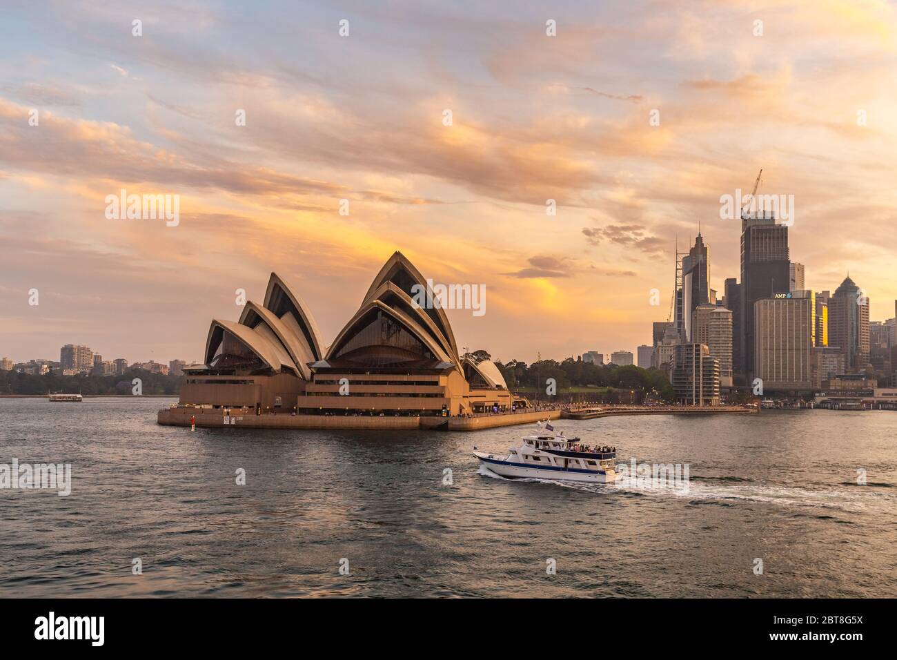 Sydney Opera House at sunset. Beautiful orange-and-yellow colors. Down ...