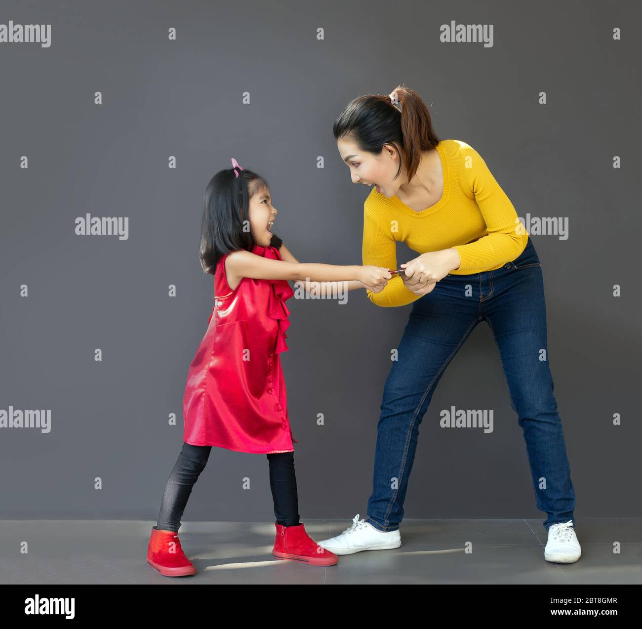 kid and mom figth over for scramble mobile phone. mobile addict concept ...