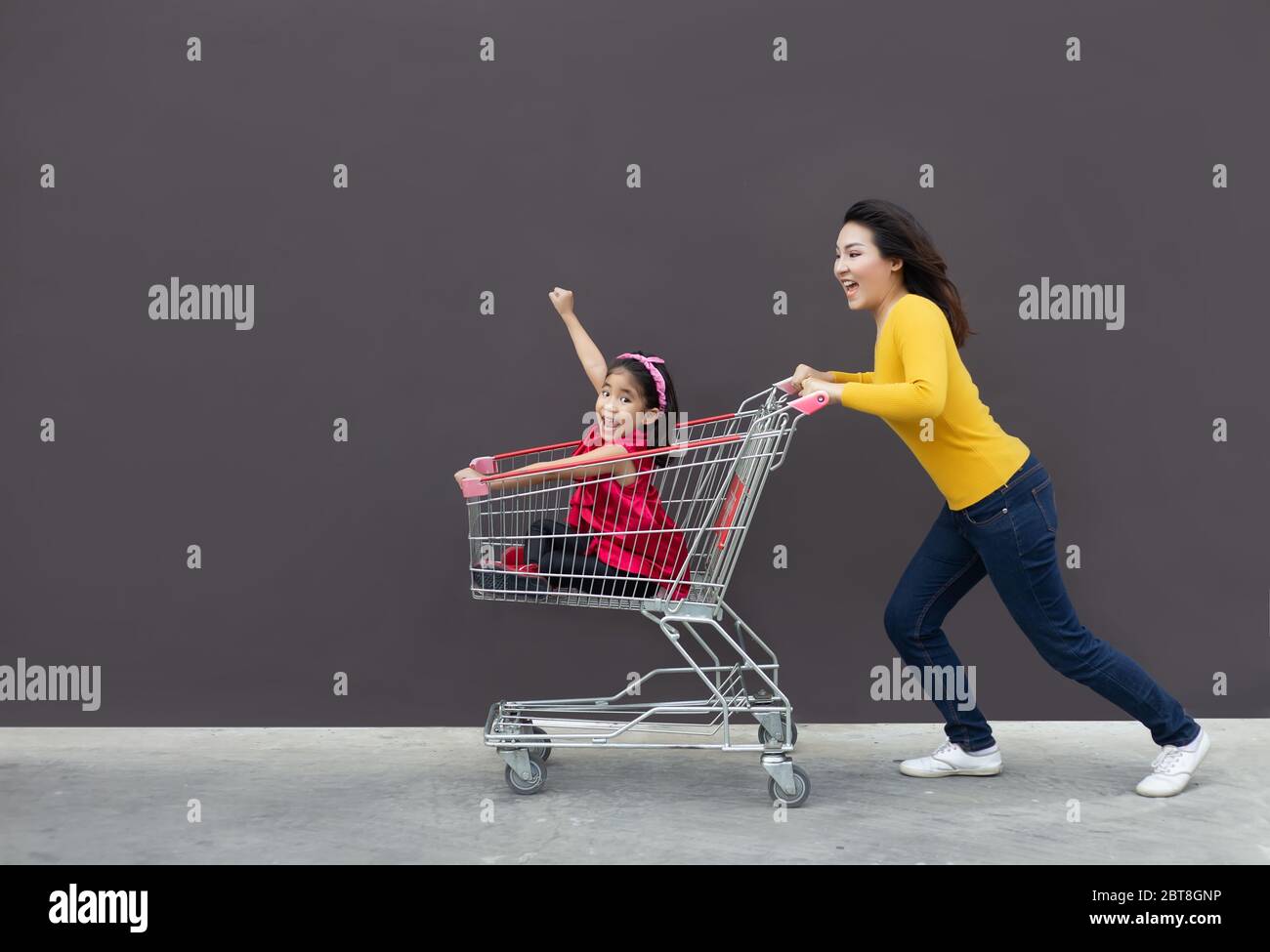 happy mom and kid go shopping cart together. Funny action of mother and ...