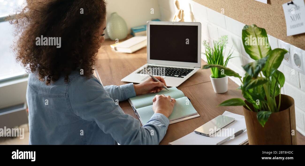 African teen girl student writing notes in notebook distance learning ...