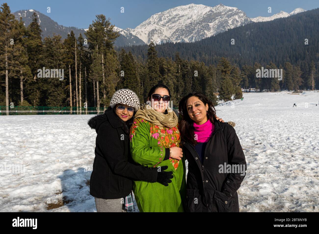 Three female tourists pose for a photo amidst the snow at the popular ...