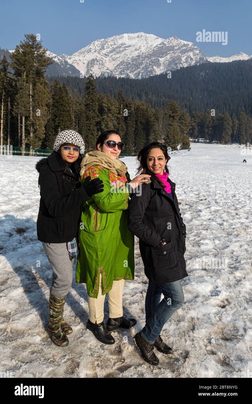 Three female tourists pose for a photo amidst the snow at the popular ...