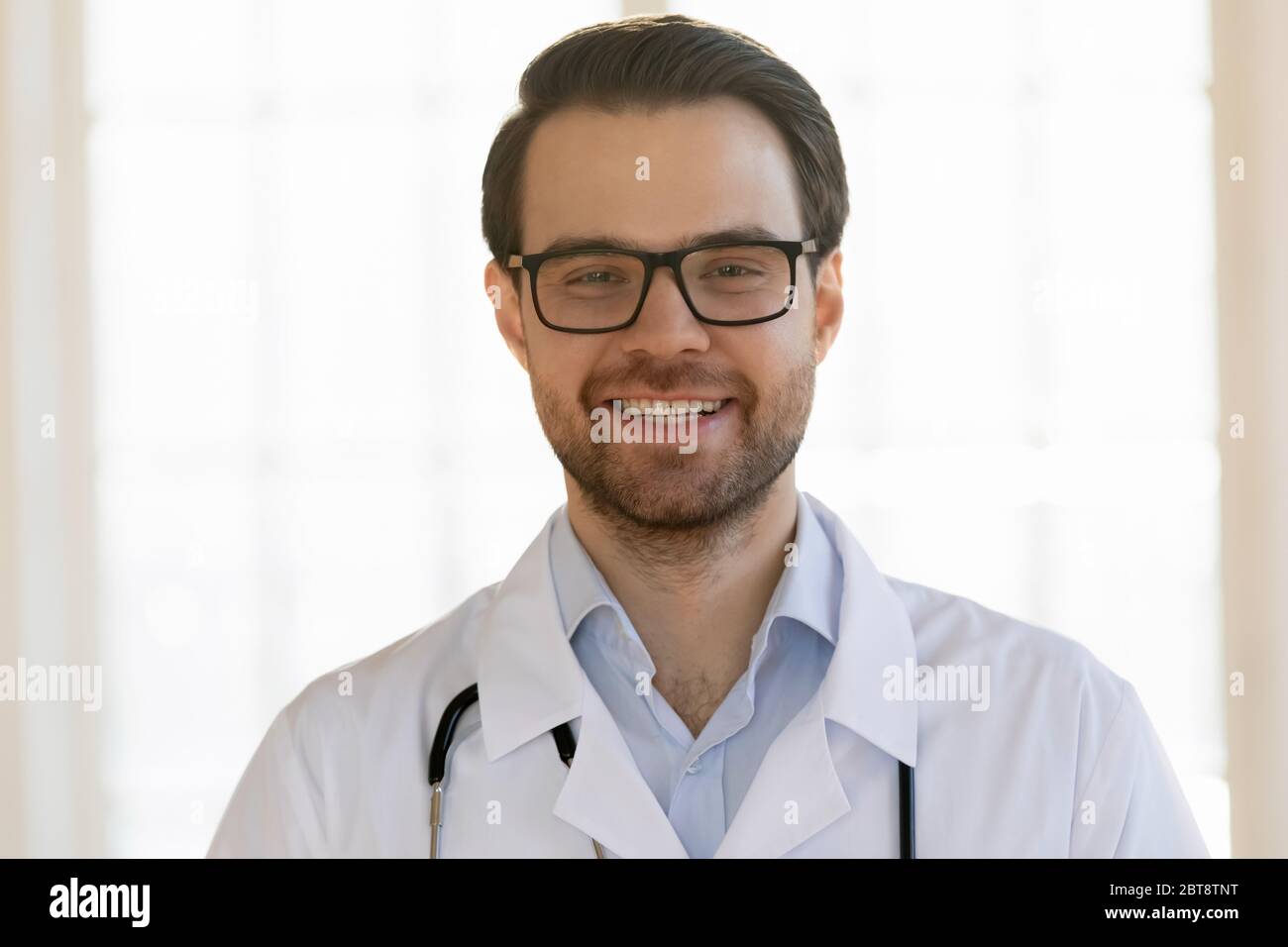 Portrait of smiling male Caucasian doctor posing at workplace Stock ...