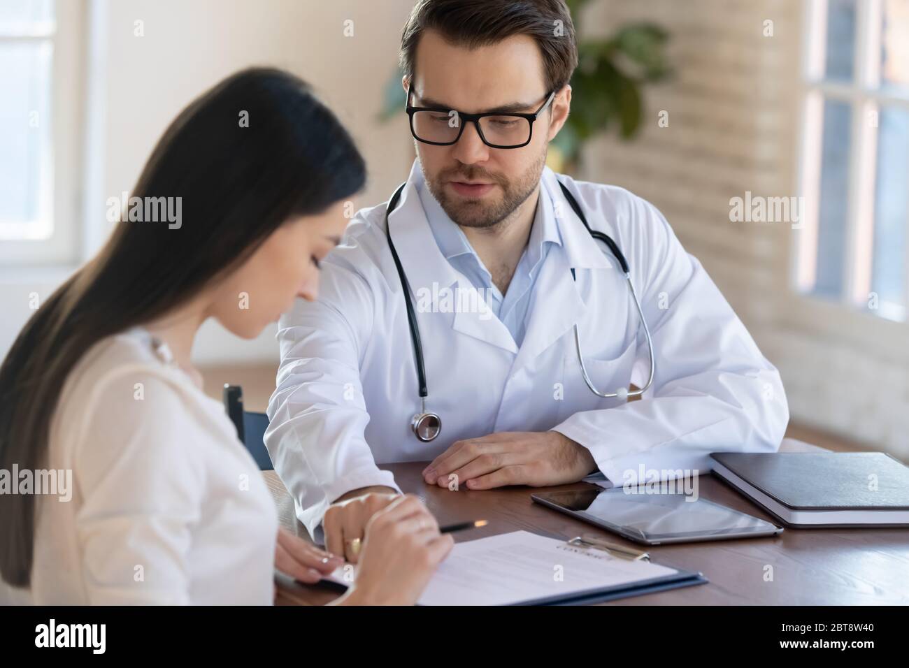 Female patient sign paper contract at meeting with doctor Stock Photo ...