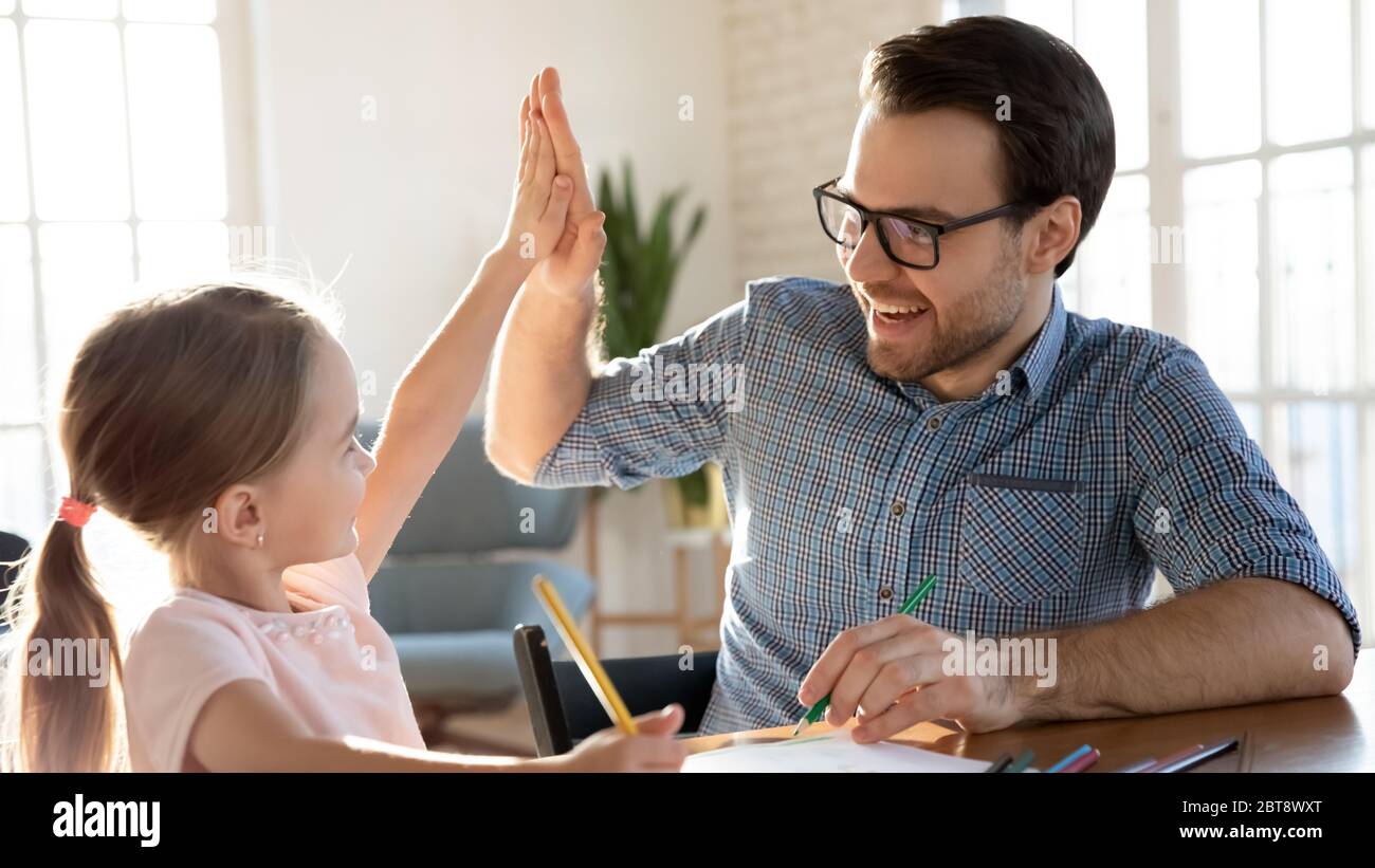 Overjoyed father and small daughter celebrate success at home Stock ...