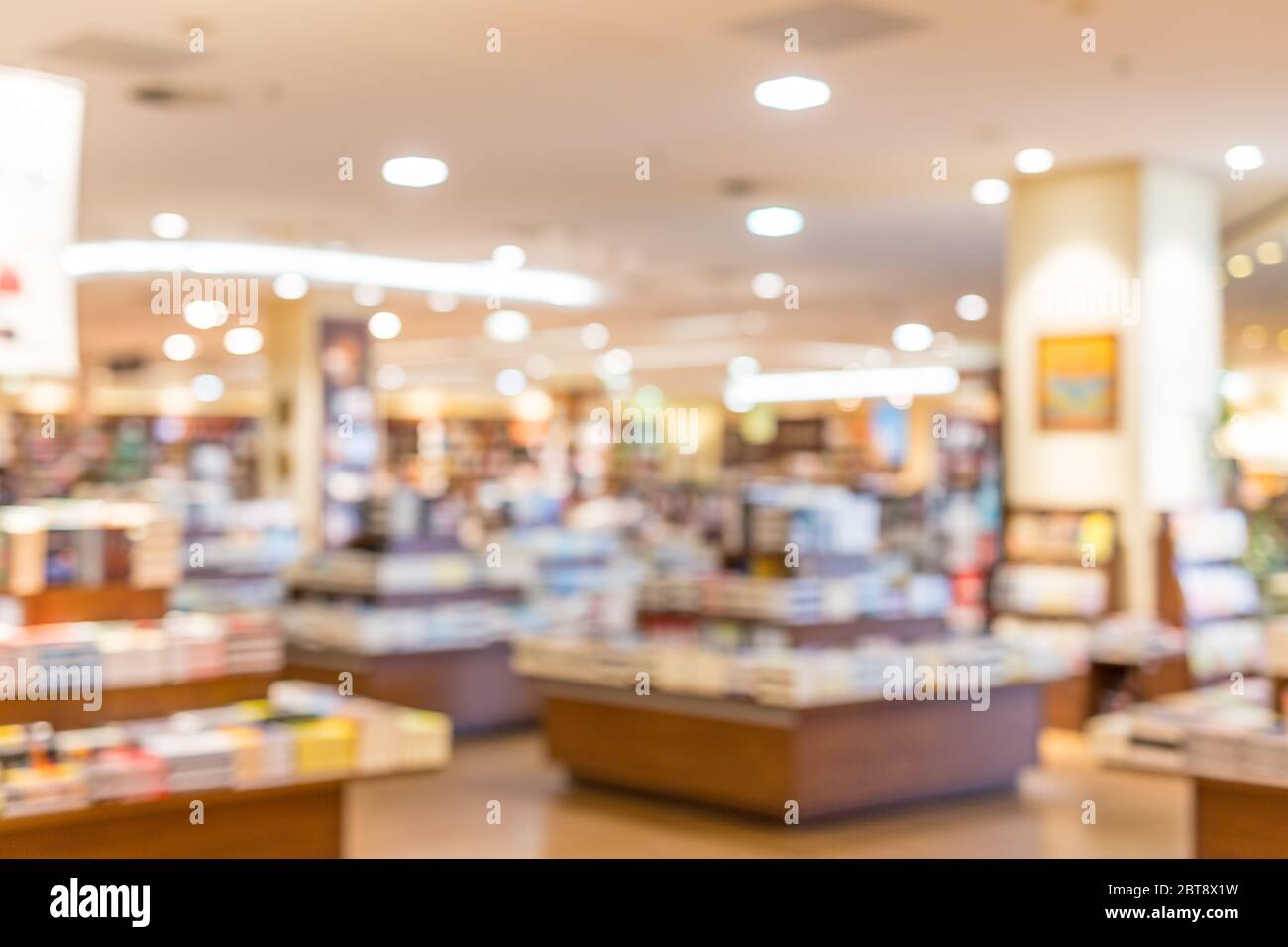 De focused blur image of a bookstore with lights and book stand ...