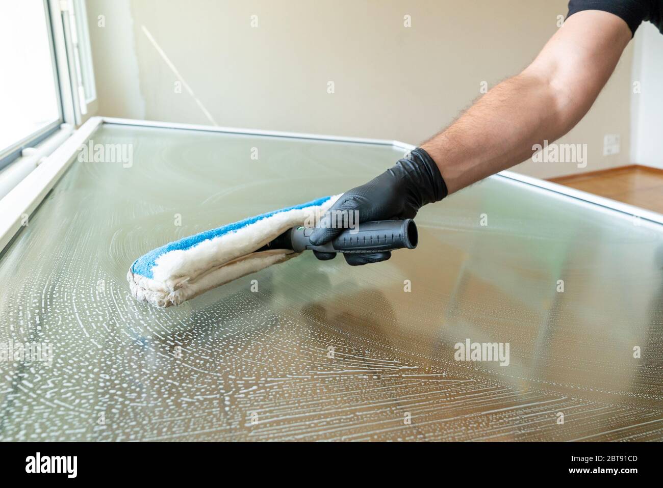 A professional cleaner using a washer sleeve to soap and clean a large ...